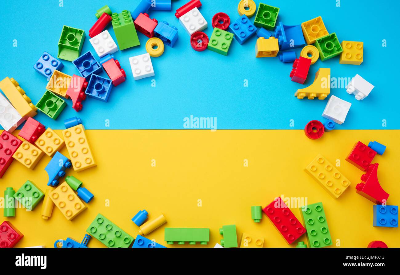 Scattered parts of a plastic children's designer, top view. Yellow blue ...