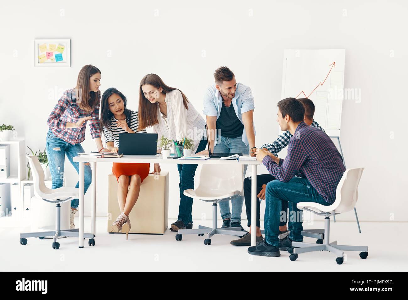 Smiling diverse group of young people working and communicating ...