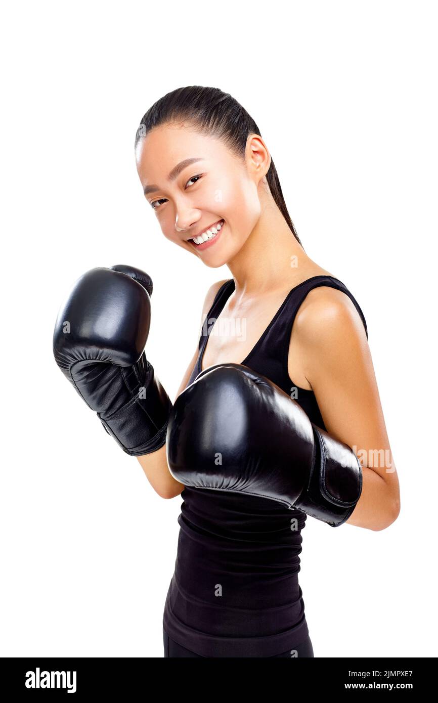 Portrait of smiling athletic woman in black boxing gloves looking at ...