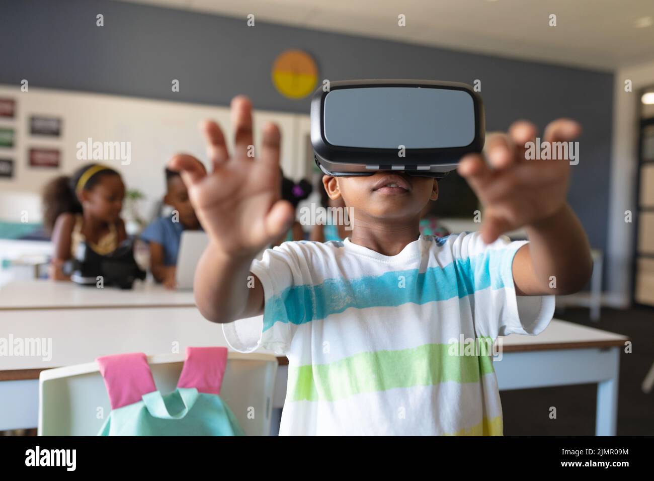 African american elementary schoolboy gesturing while wearing vr ...