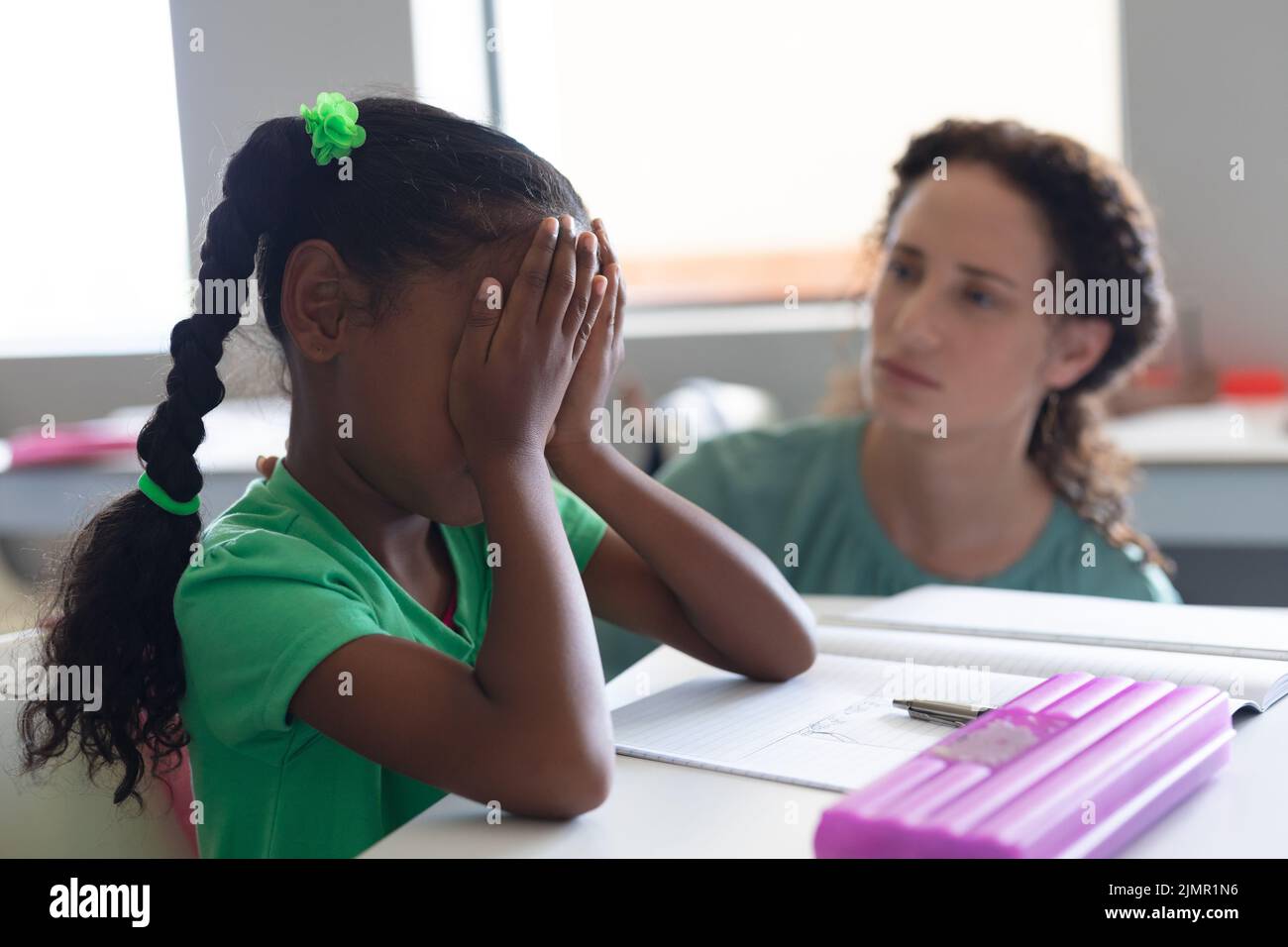 Caucasian young female teacher consoling sad african american ...