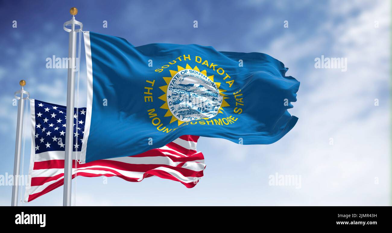 The South Dakota state flag waving along with the national flag of the ...