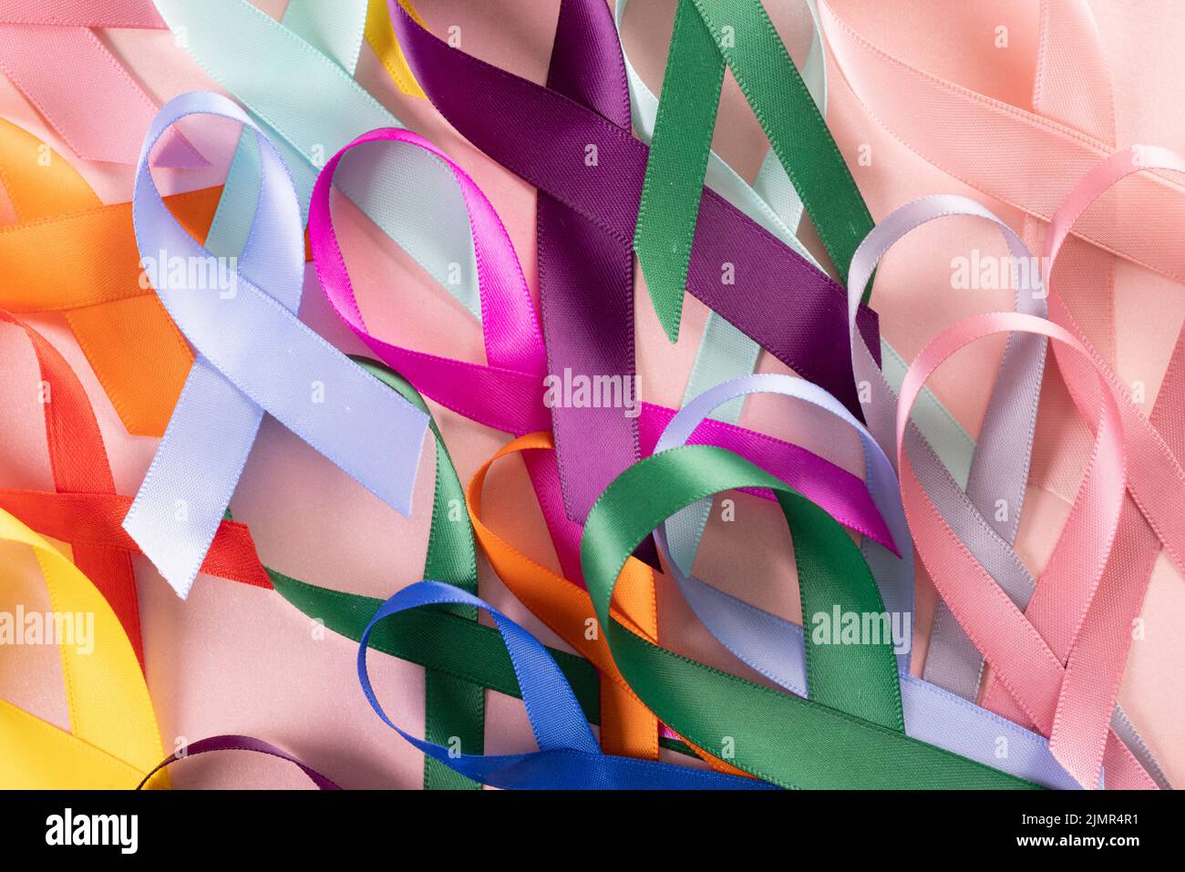Extreme close-up of various colorful awareness ribbons on pink ...