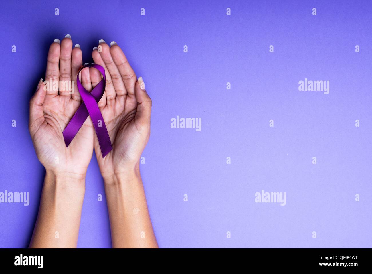 African american mid adult woman's hands with purple awareness ribbon ...
