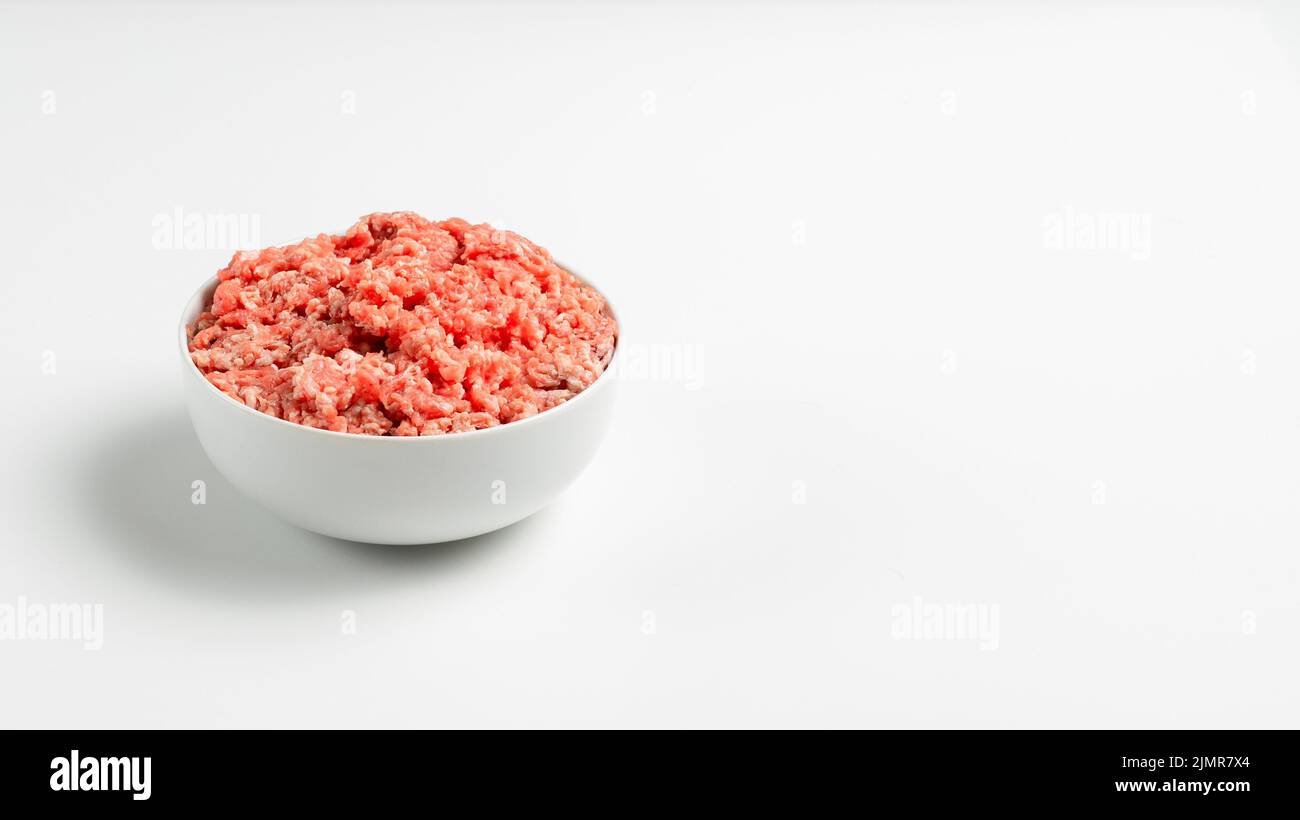 Plate with fresh ground beef on a white background, space for text ...