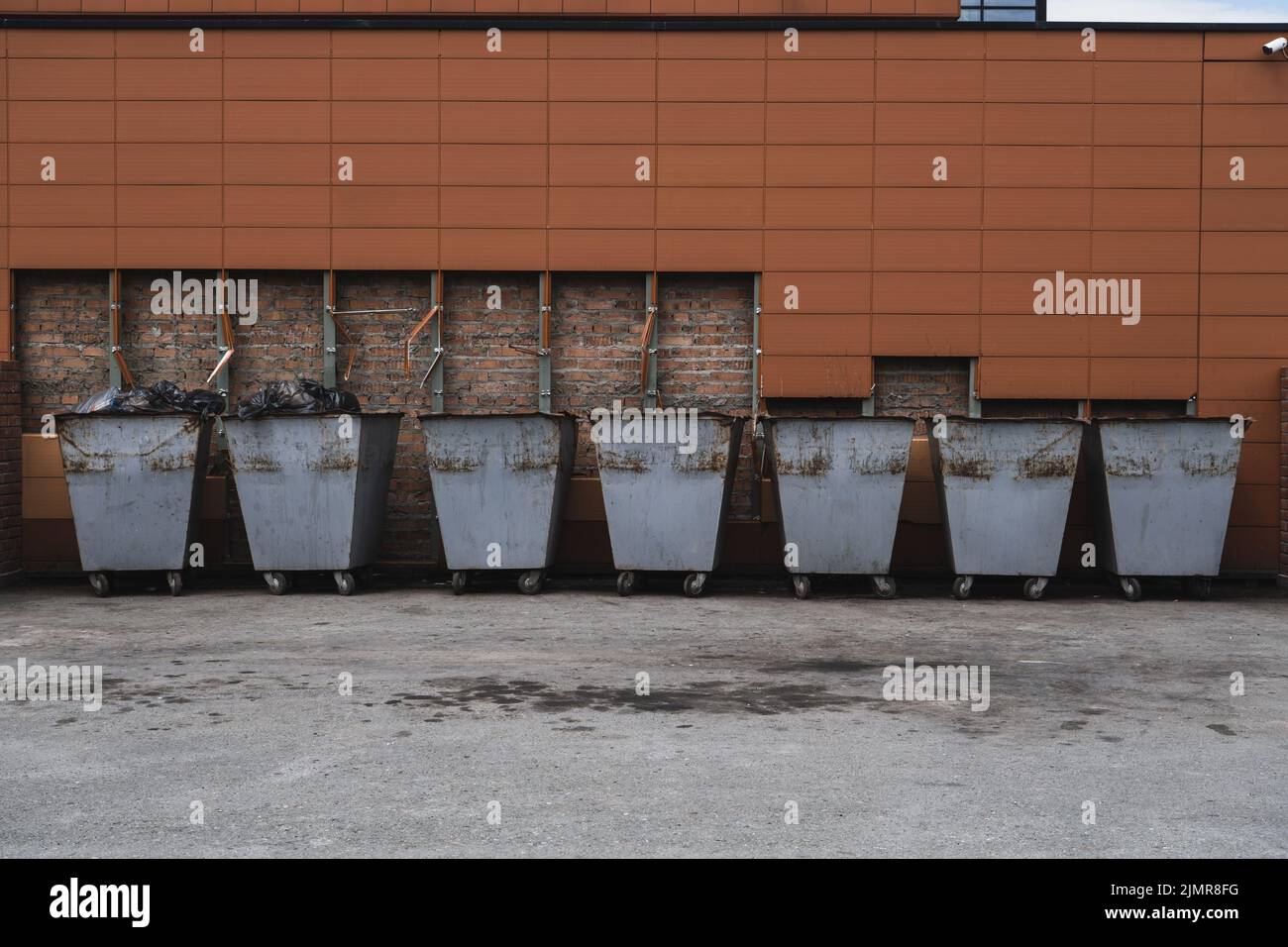 Many old rusty trash cans standing in a row Stock Photo - Alamy
