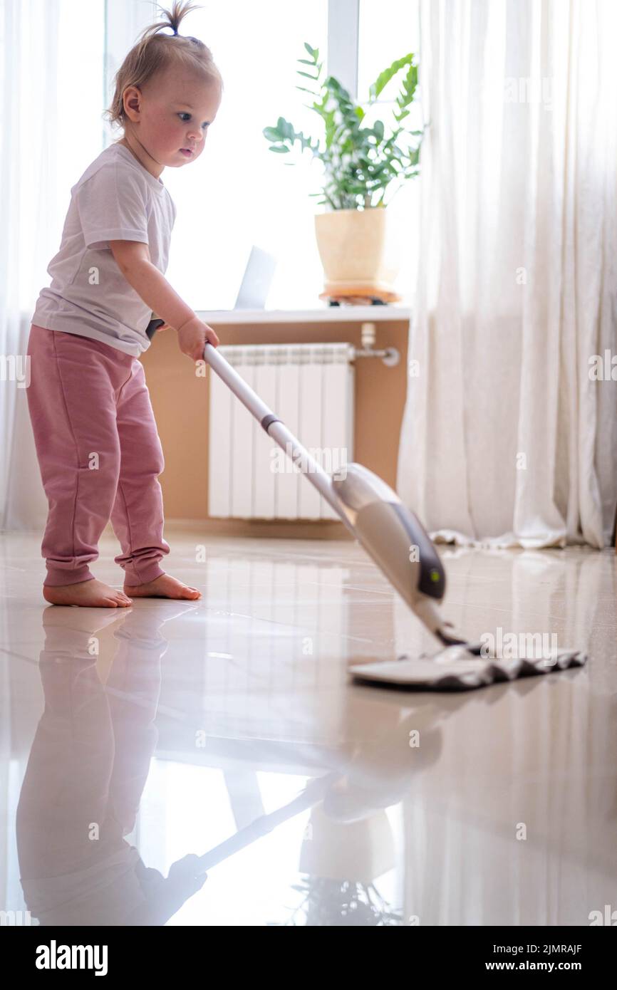 little daughter cleaning in the house, child dusting, Cute little ...