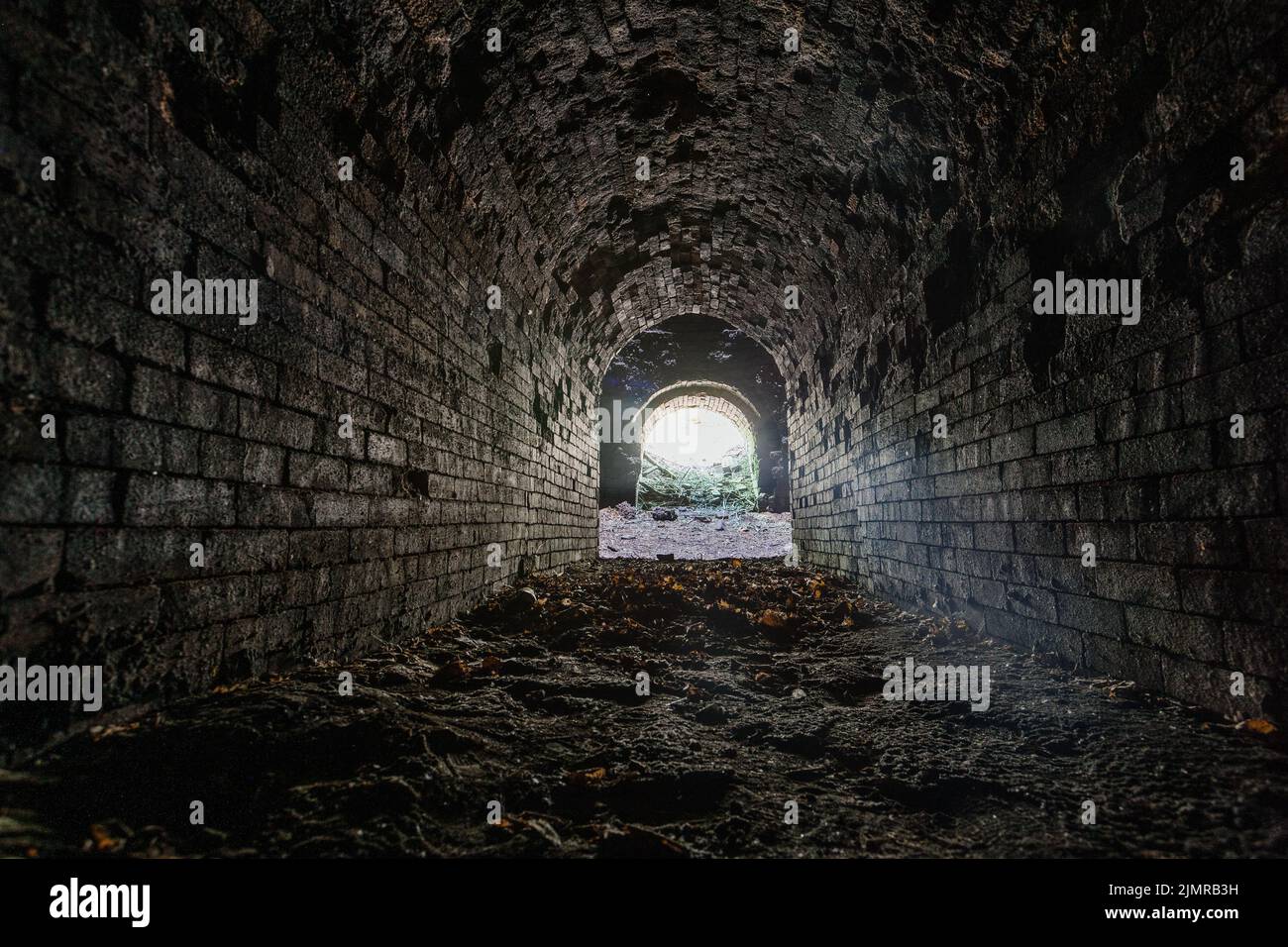 Historical underground red brick passage. Light at the end of tunnel ...