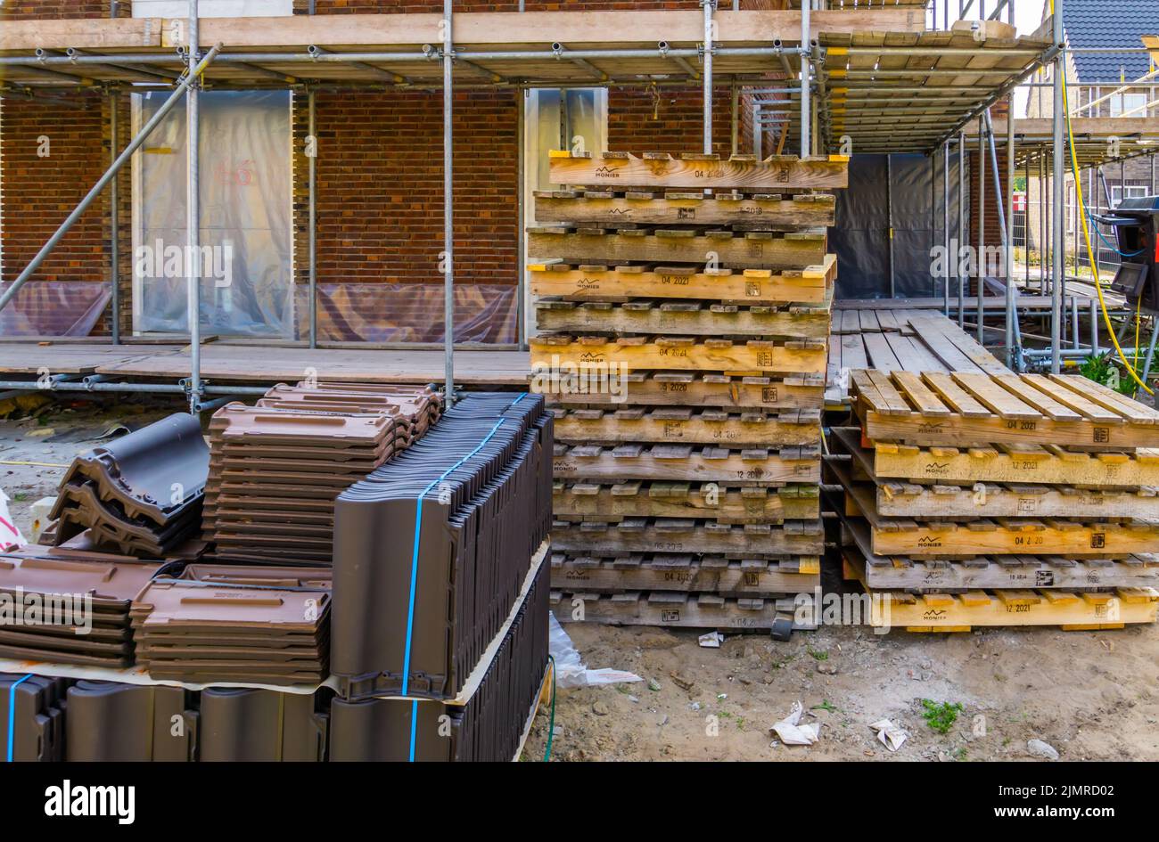 Pallet of roof tiling with jetty and empty pallets in background ...