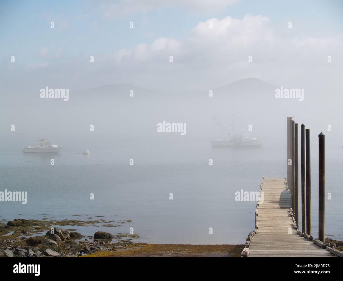 Early morning fog settles in on fishing boat and dock,coastal Maine ...