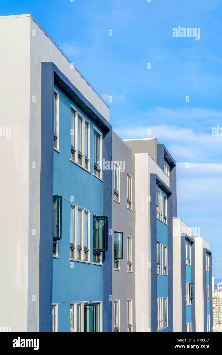Side view of an apartment building exterior with blue and white walls ...