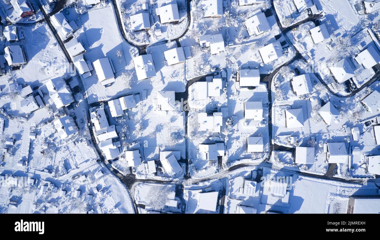 A bird's eye view of a a residential neighborhood covered in snow ...
