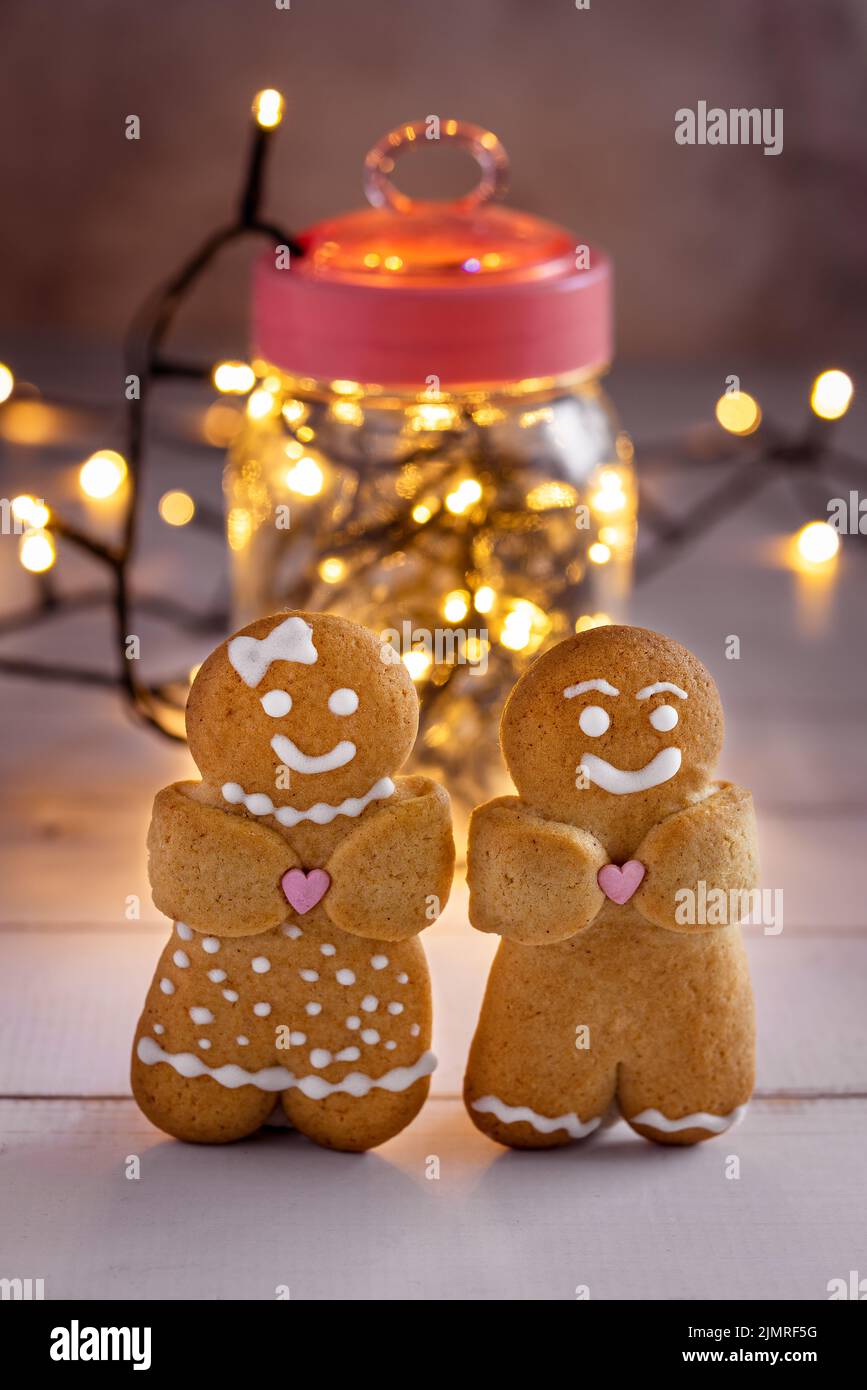 Two gingerbread men on the background of a jar with garlands Stock ...