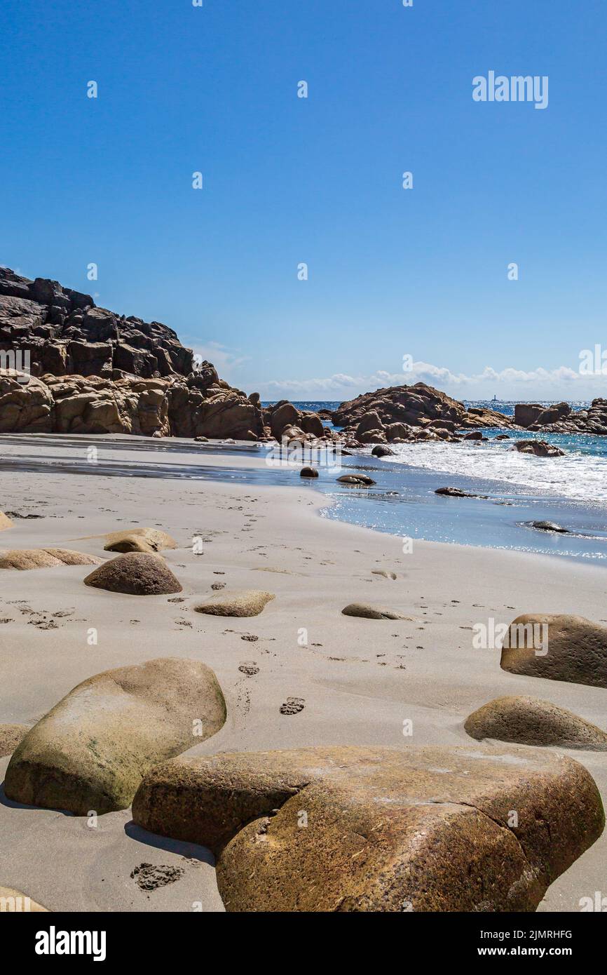 Rock formations on Porth Nanven beach at low tide, with a blue sky ...