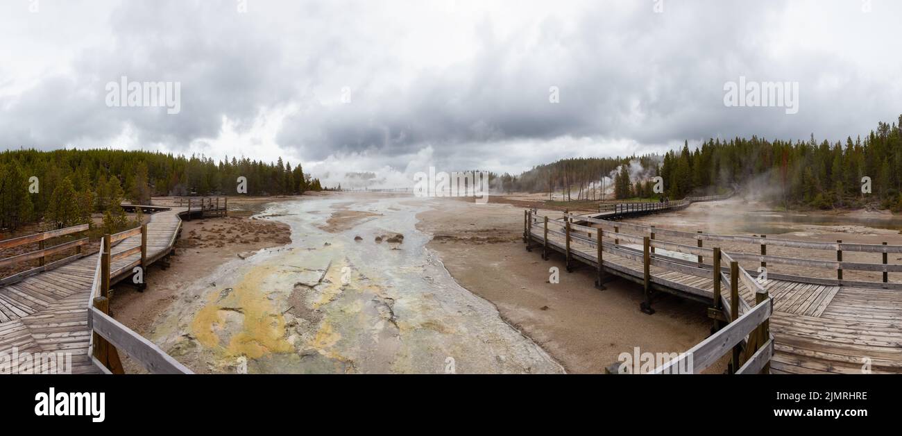 Wooden hiking path in Hot spring Geyser with colorful water in American ...