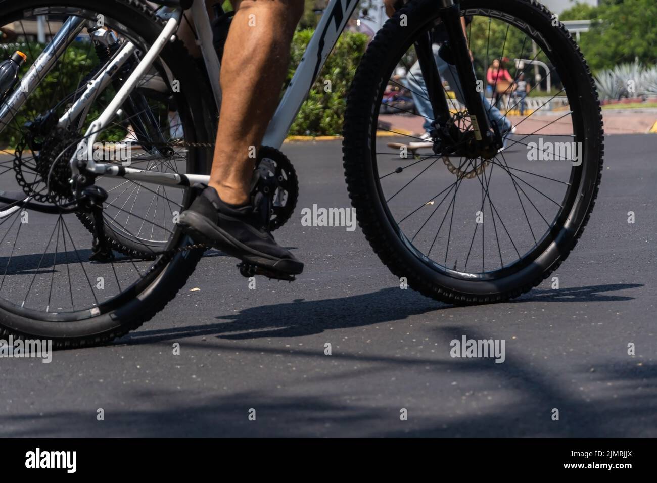 A young man riding his bicycle down the street on a sunny day Stock ...