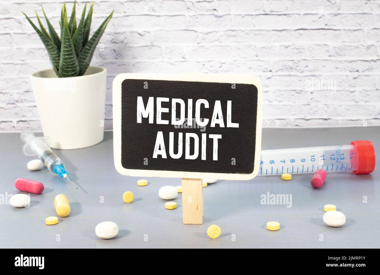 Doctor holding a business card with capital lettering MEDICAL AUDIT in ...