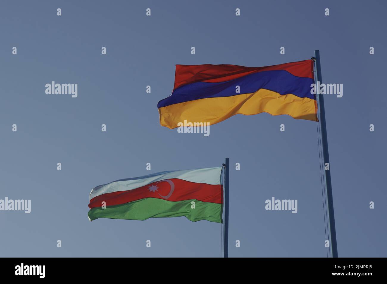 The national flags of Azerbaijan and Armenia are fluttering in the wind ...
