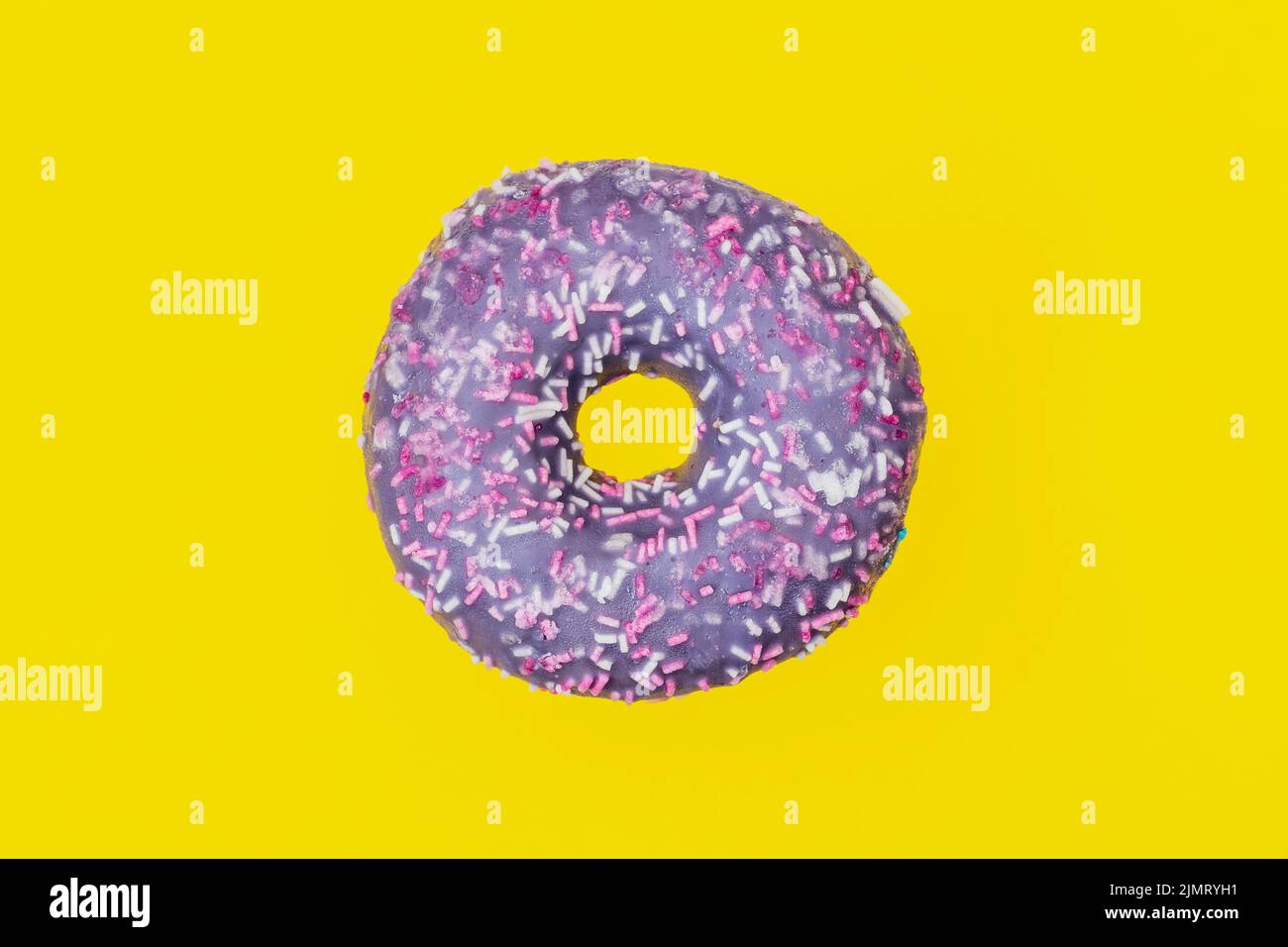 Purple donut with colorful sprinkles on a yellow background Stock Photo ...