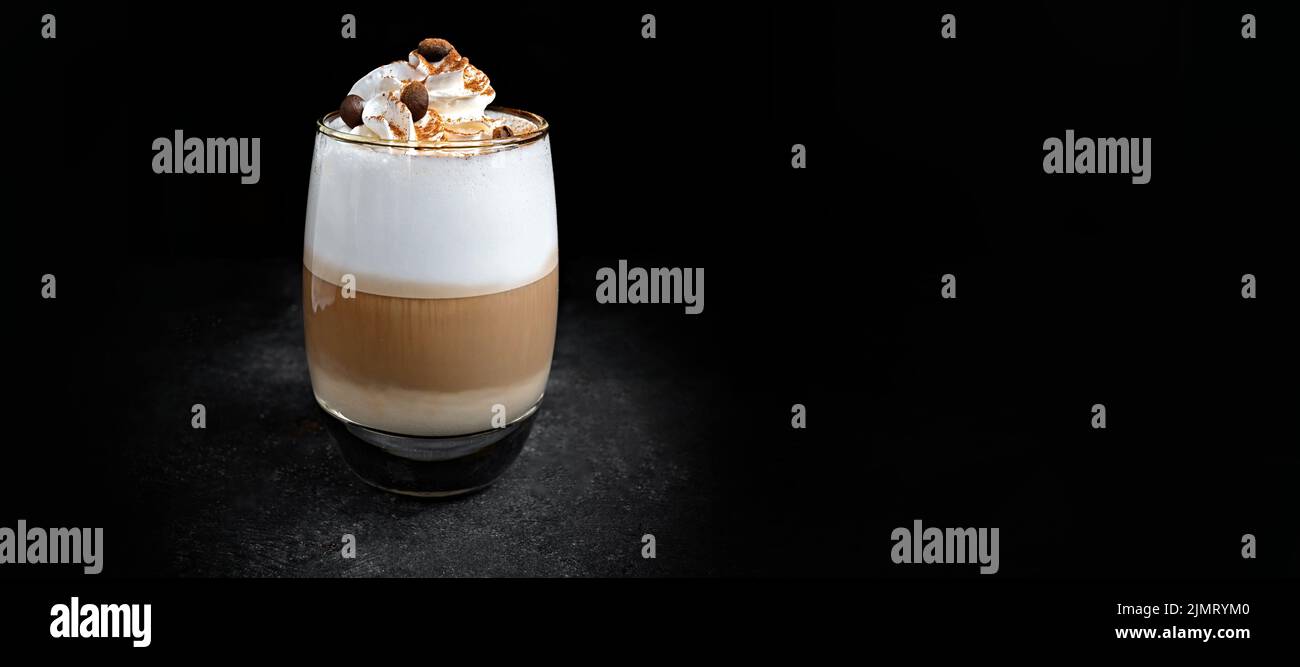 Coffee Latte with cream, coffee beans and cinnamon in a glass cup on a ...