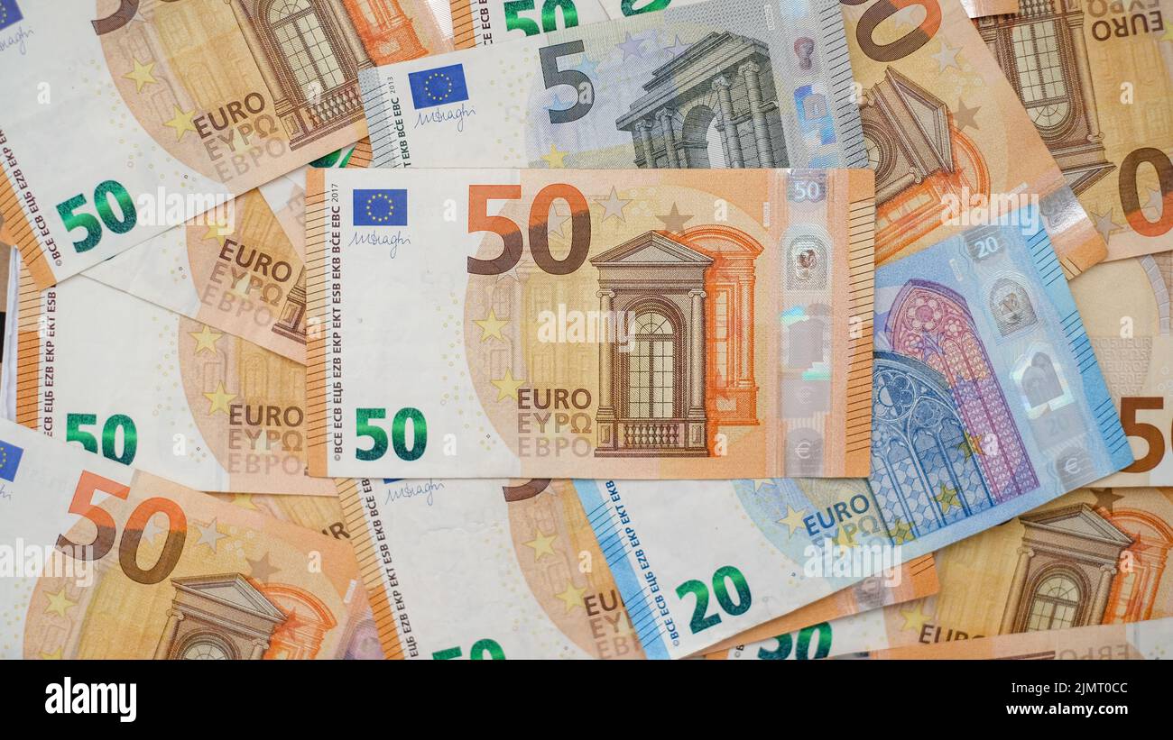 The background consists of many euro banknotes of different ...