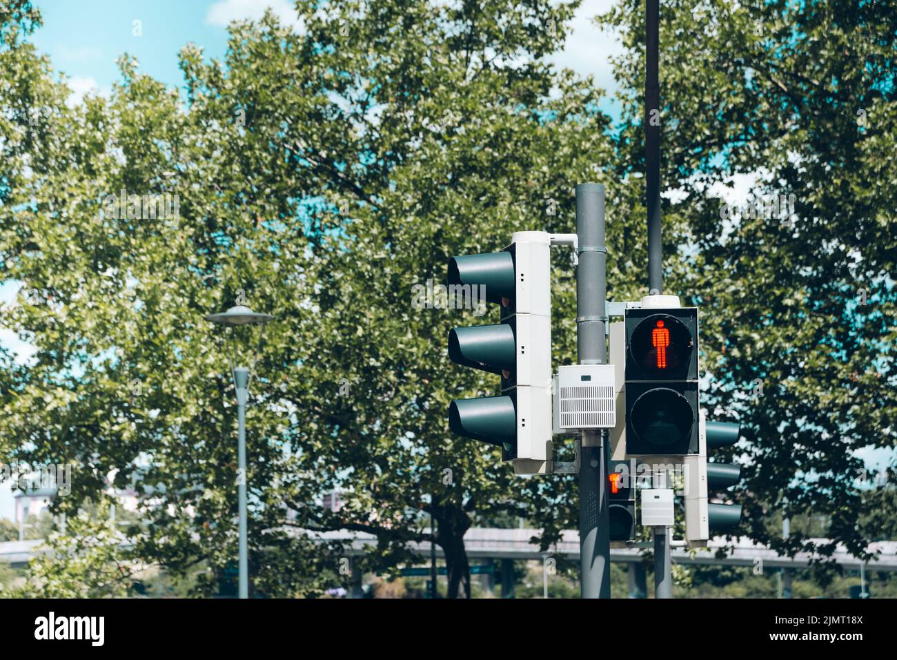 A modern pedestrian traffic lights with red stop signal against a ...