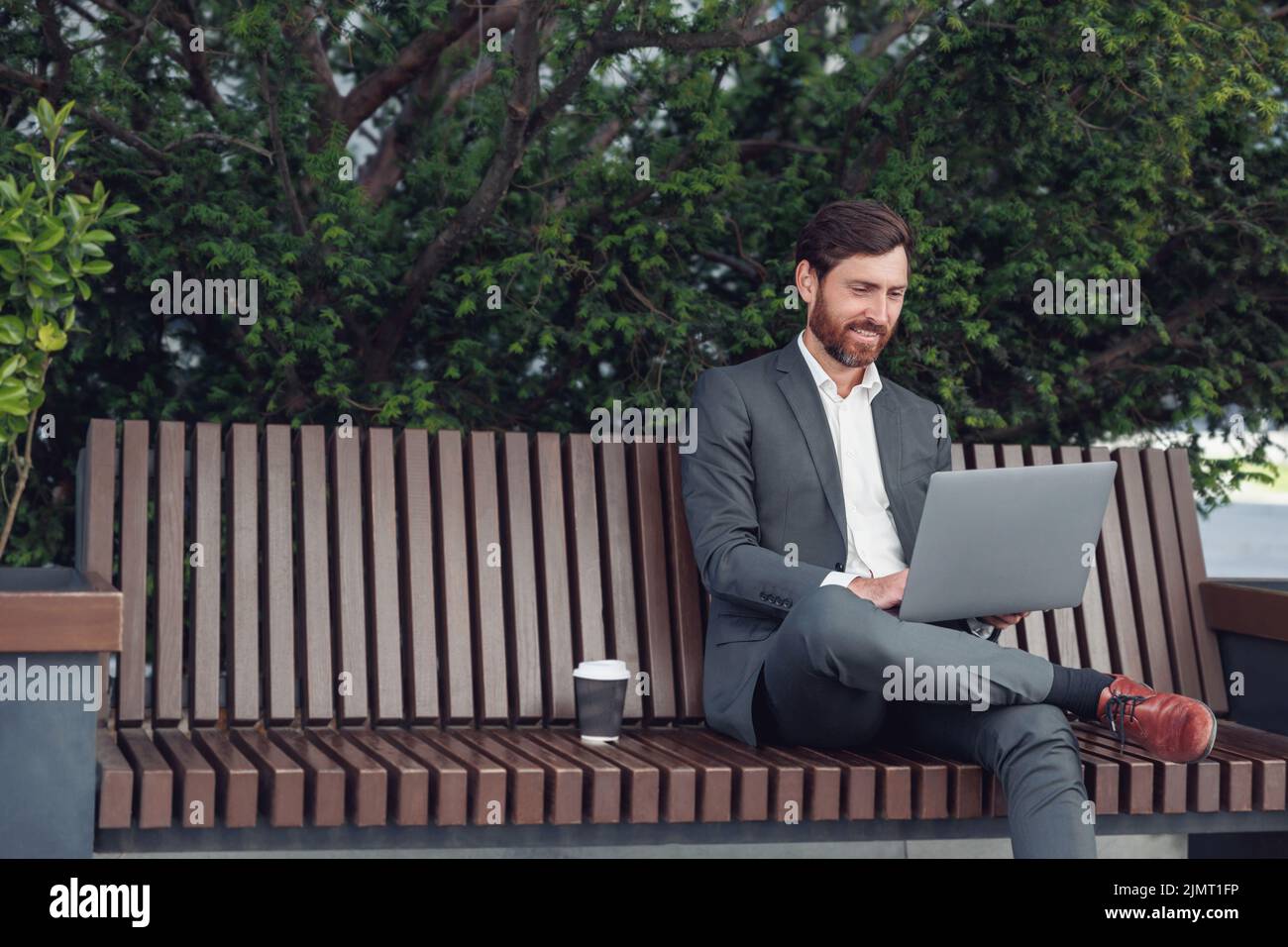 Business man office worker working on laptop in urban park background ...