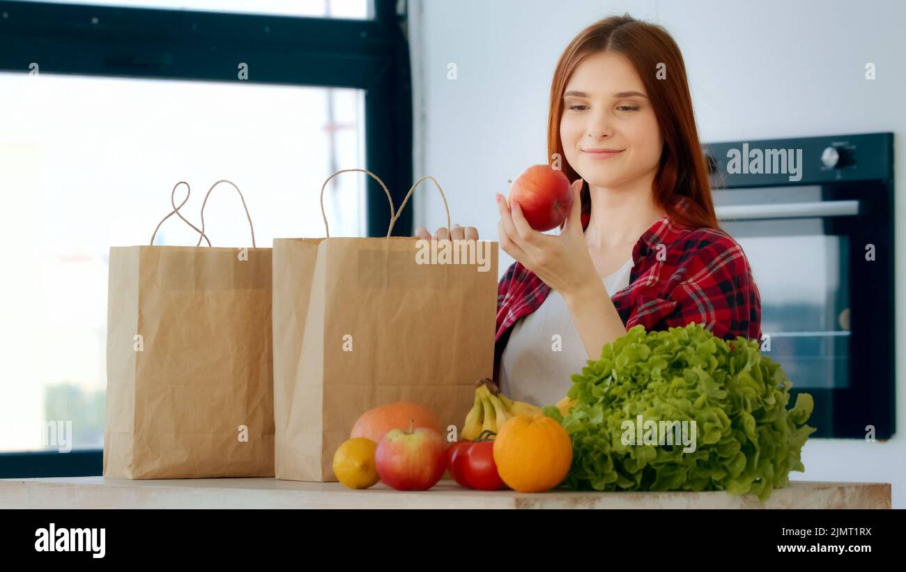 Female consumer woman caucasian buyer unpacks groceries from paper eco ...