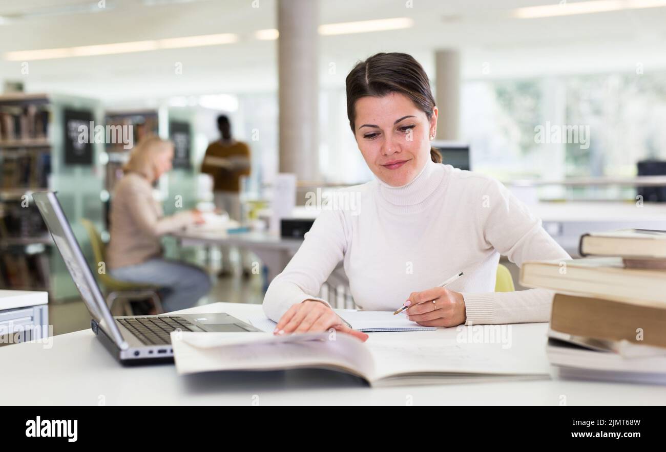 Successful woman studying in the library Stock Photo - Alamy