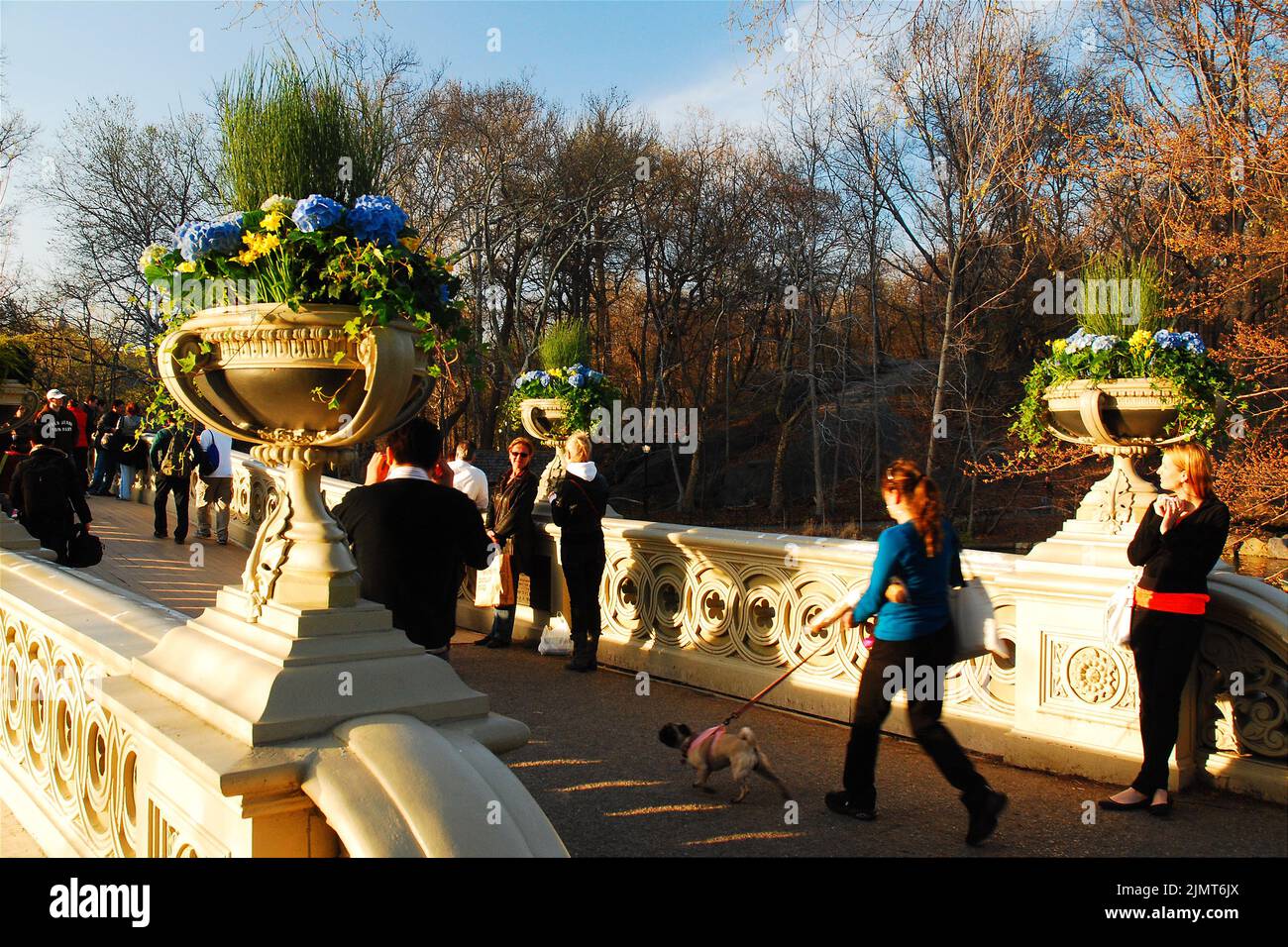 People enjoy a warm sunny spring day standing on or crossing the Bow ...