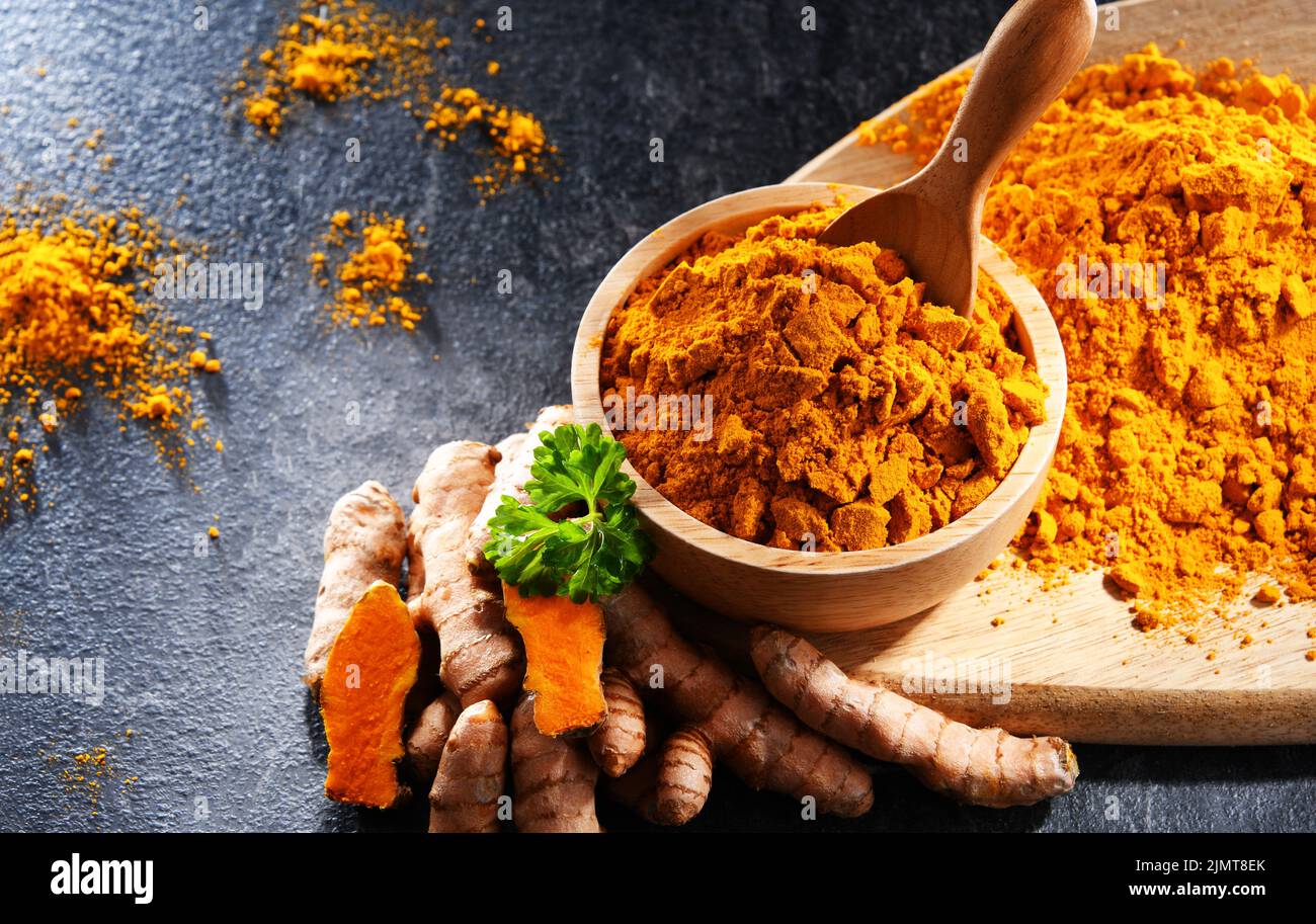 Composition with a bowl of ground turmeric and its fresh rhizome Stock ...