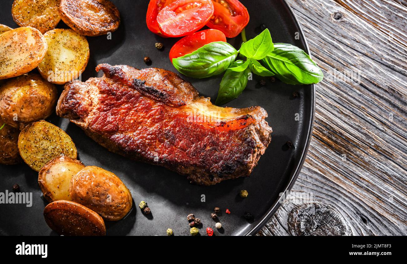 Pan-fried beef steak with fried potatoes and cherry tomatoes Stock ...