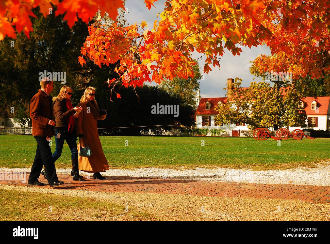 A group of friends take a leisurely stroll on a crisp autumn day to ...