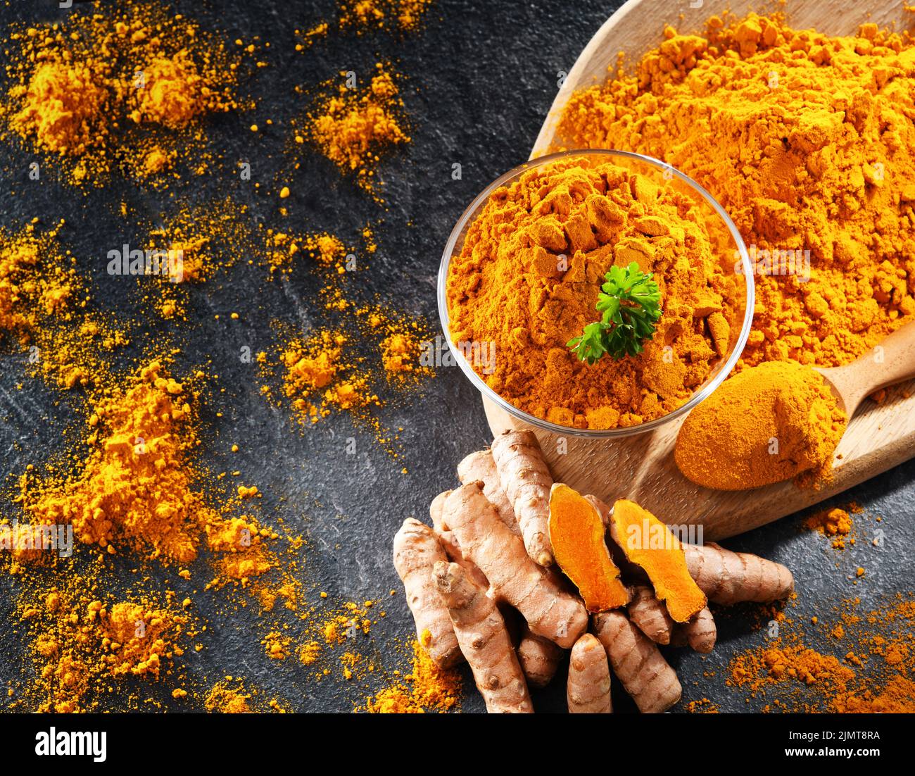 Composition with a bowl of ground turmeric and its fresh rhizome Stock ...