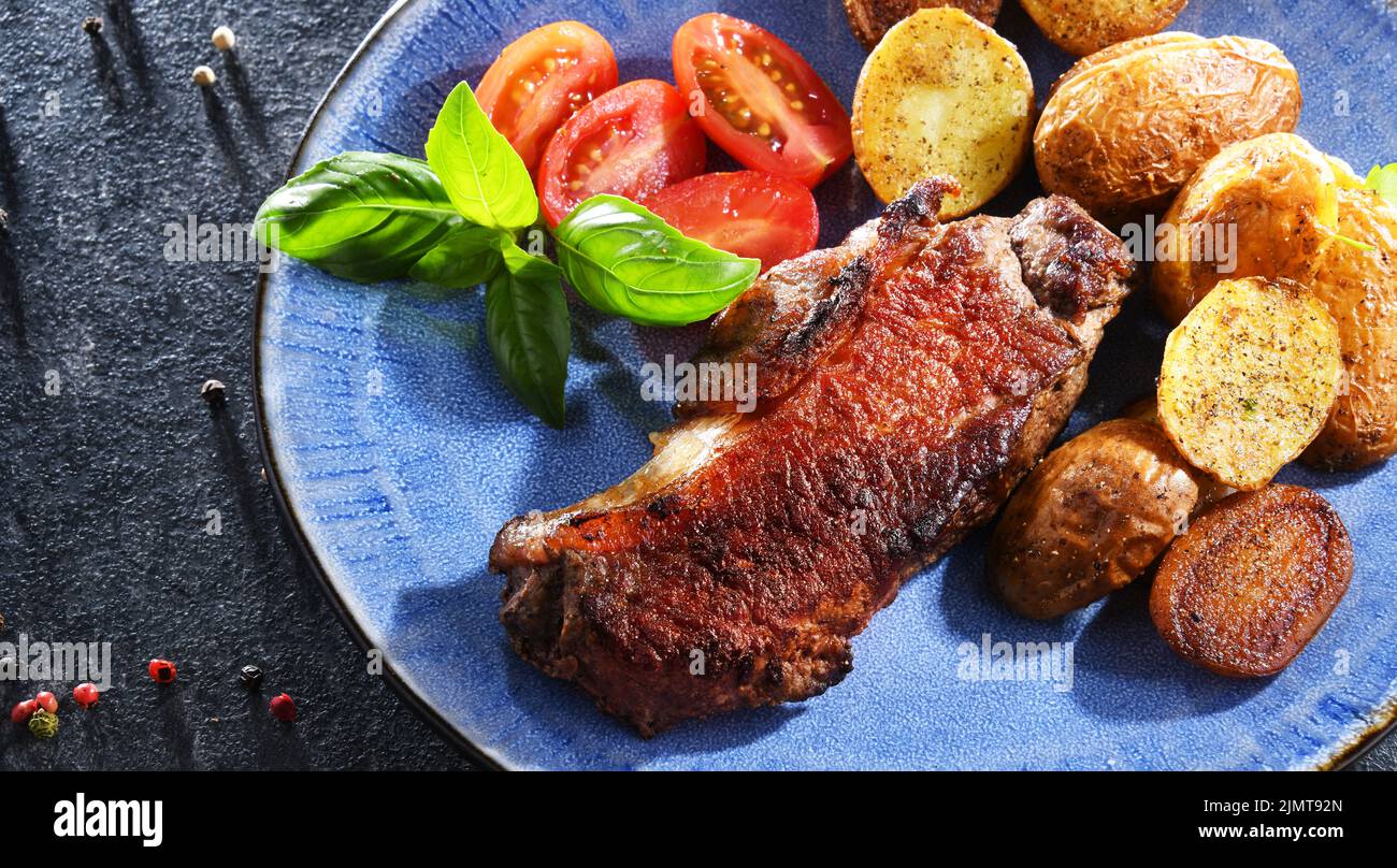 Pan-fried beef steak with fried potatoes and cherry tomatoes Stock ...