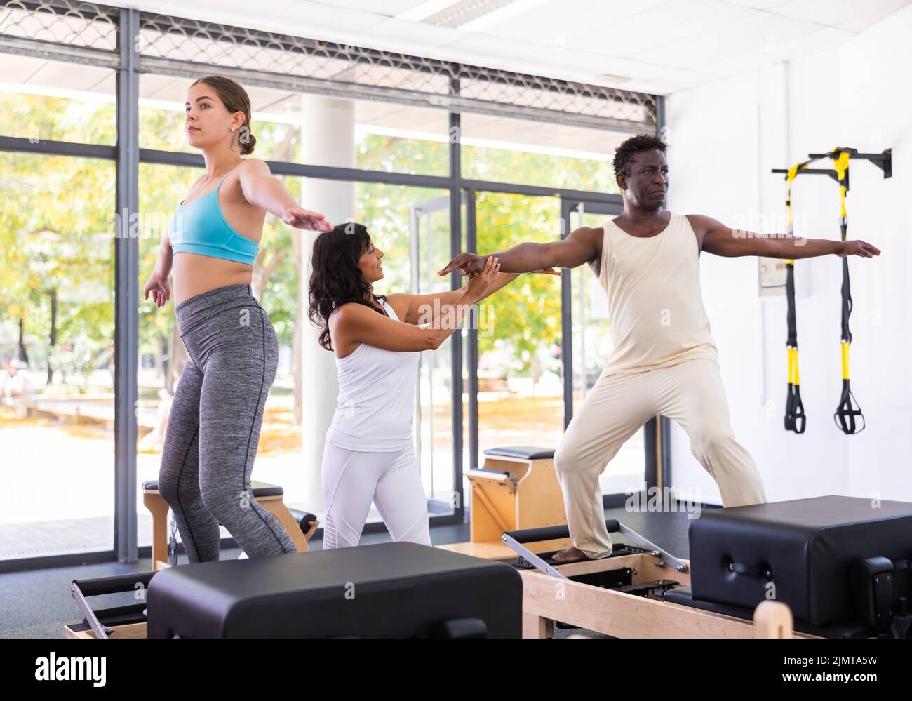 Female pilates trainer helping pilates people during training Stock ...