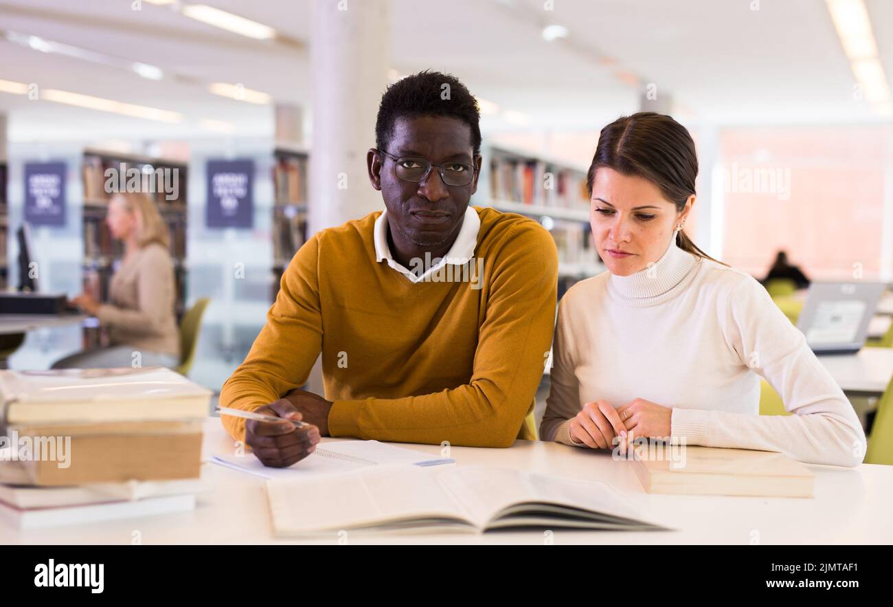 People reading and making notes while preparing for exam in library ...