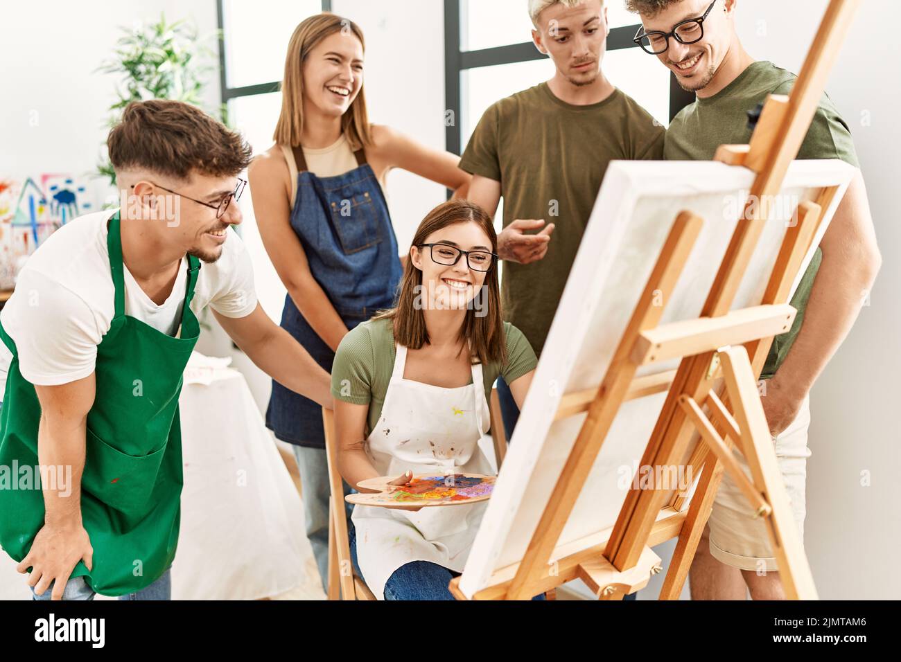 Group of people smiling happy and looking draw of partner at art studio ...