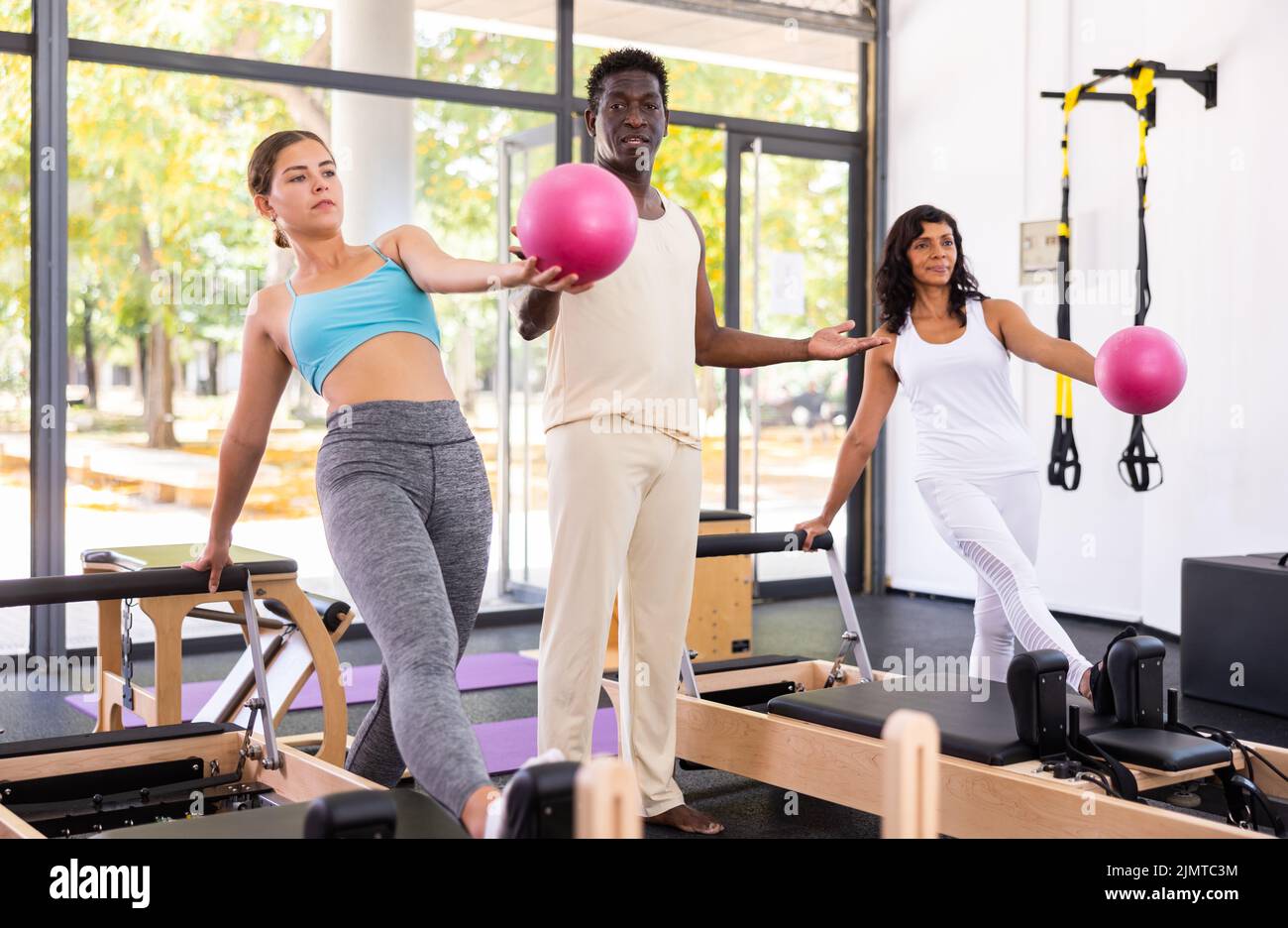 Portrait of two young sporty woman during group core training with ...