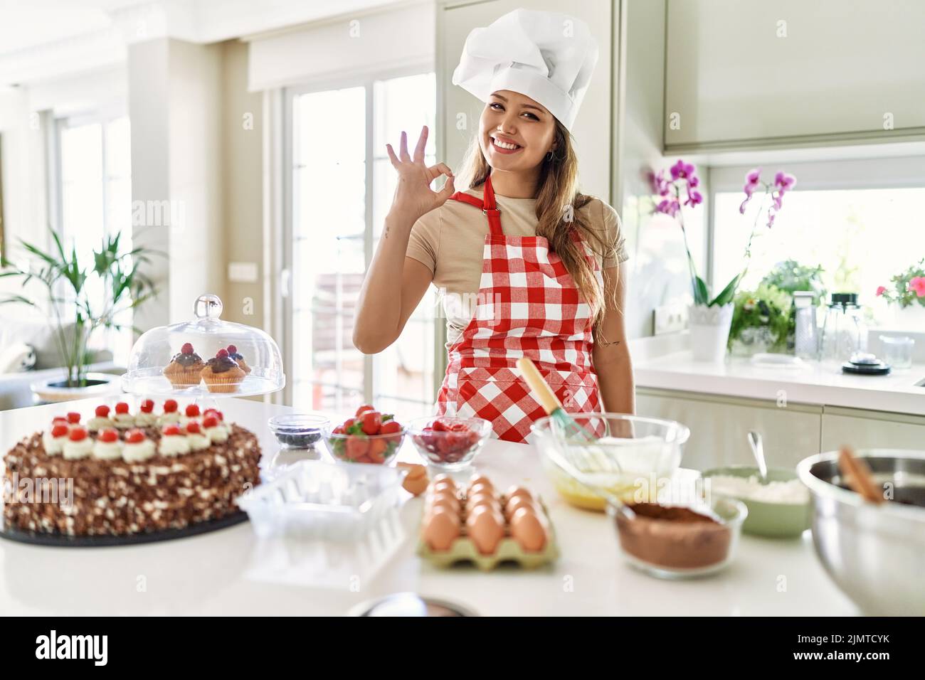 Beautiful young brunette pastry chef woman cooking pastries at the ...