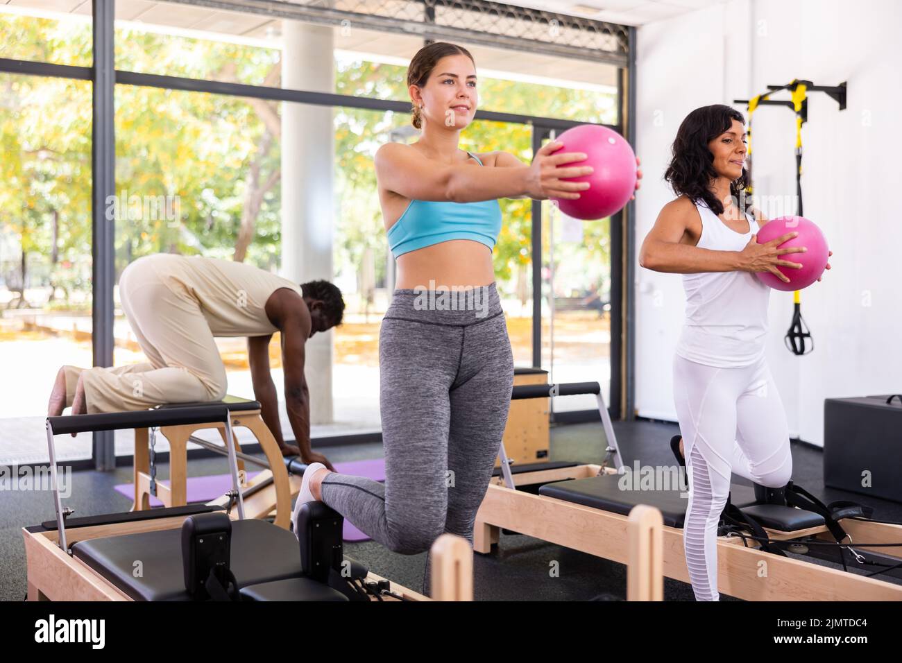 Portrait of two young sporty woman during group core training with ...