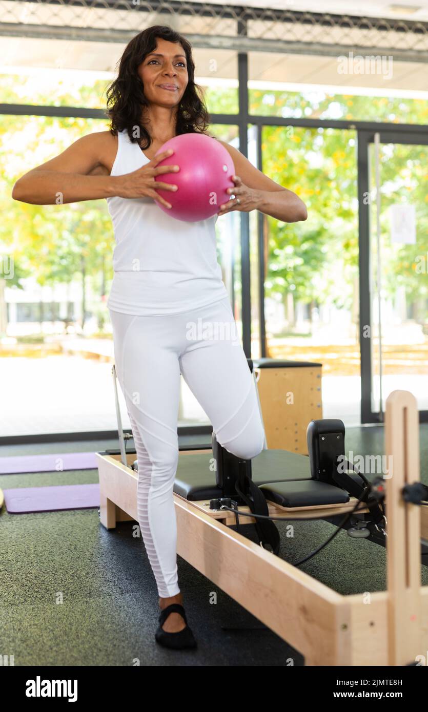 Positive woman doing exercises with pilates ball in gym Stock Photo - Alamy