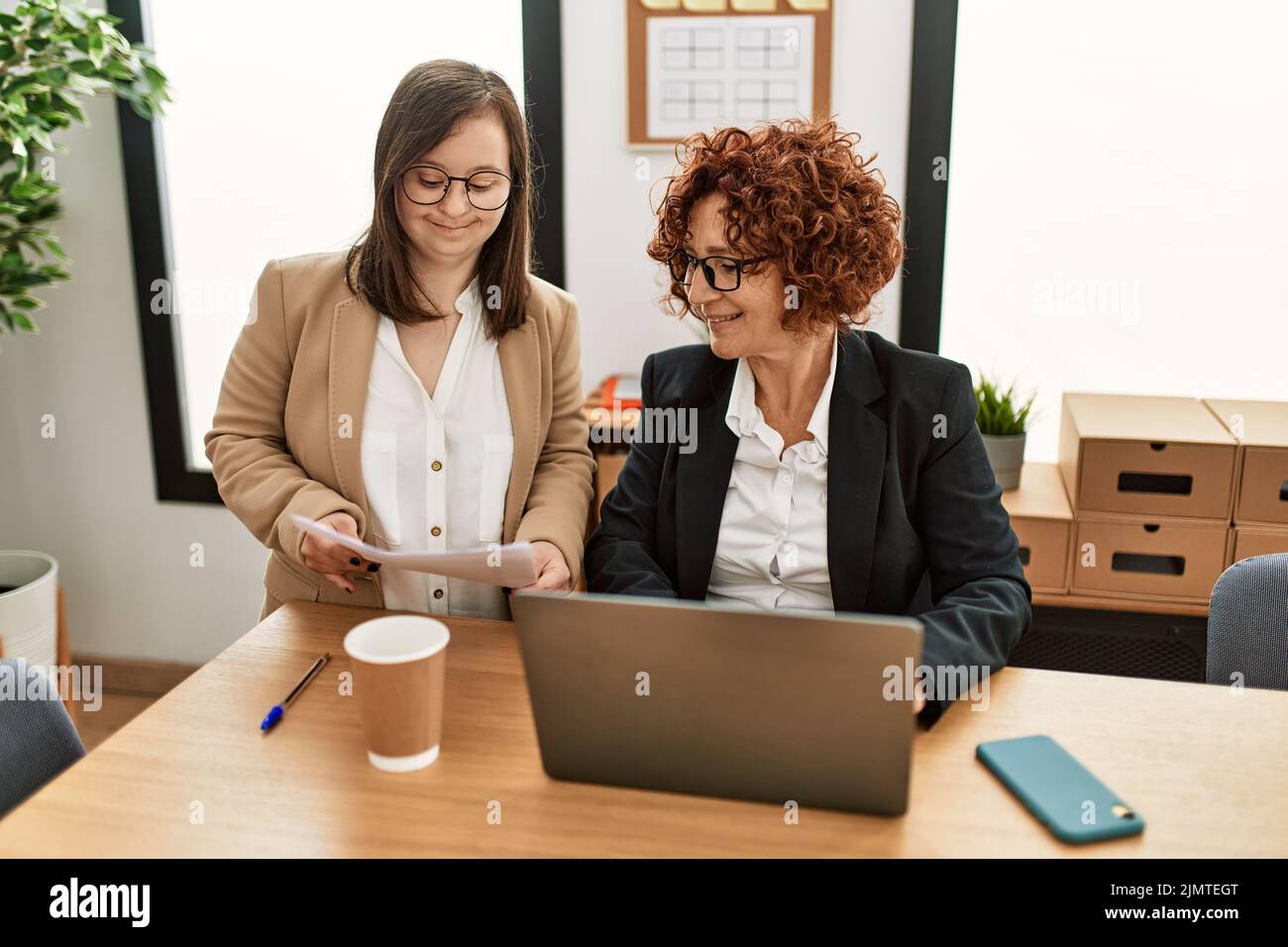 Group of two women working at the office. Mature woman and down ...