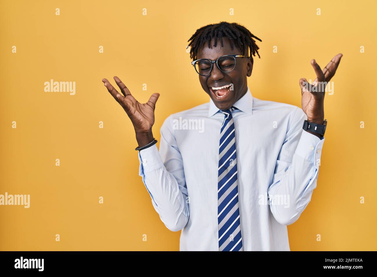 African man with dreadlocks standing over yellow background celebrating ...