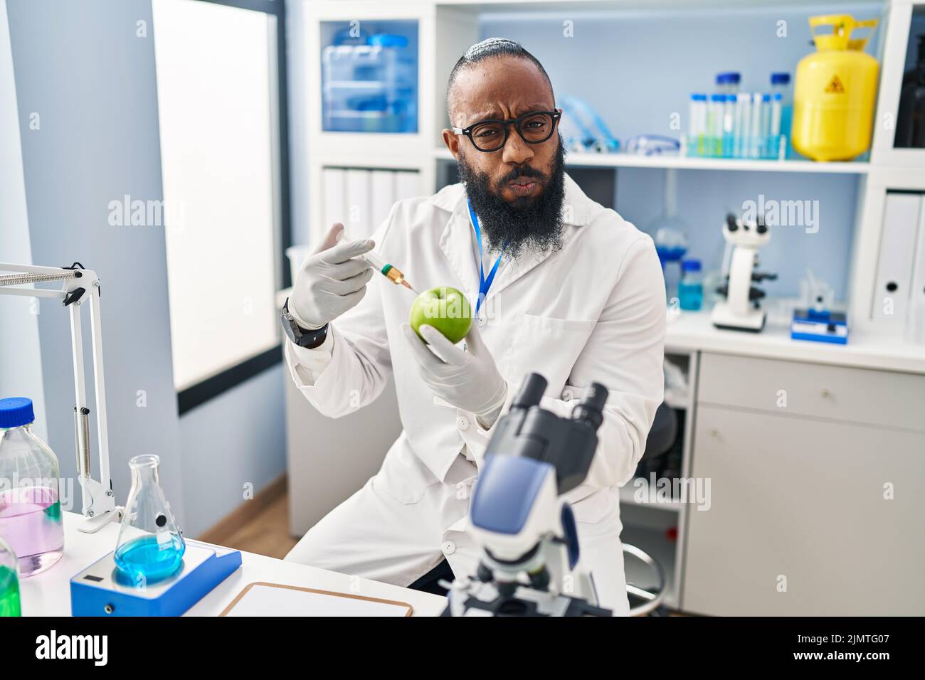 African american man working at scientist laboratory with apple puffing ...