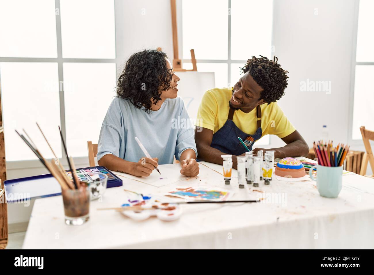 African american artist couple smiling happy painting sitting on the ...