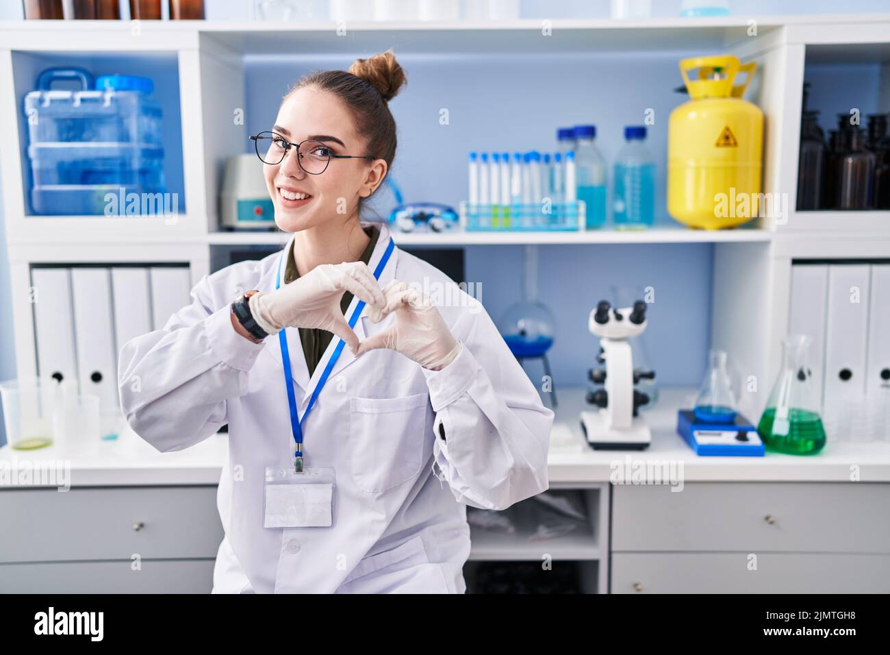 Young hispanic girl working at scientist laboratory smiling in love ...