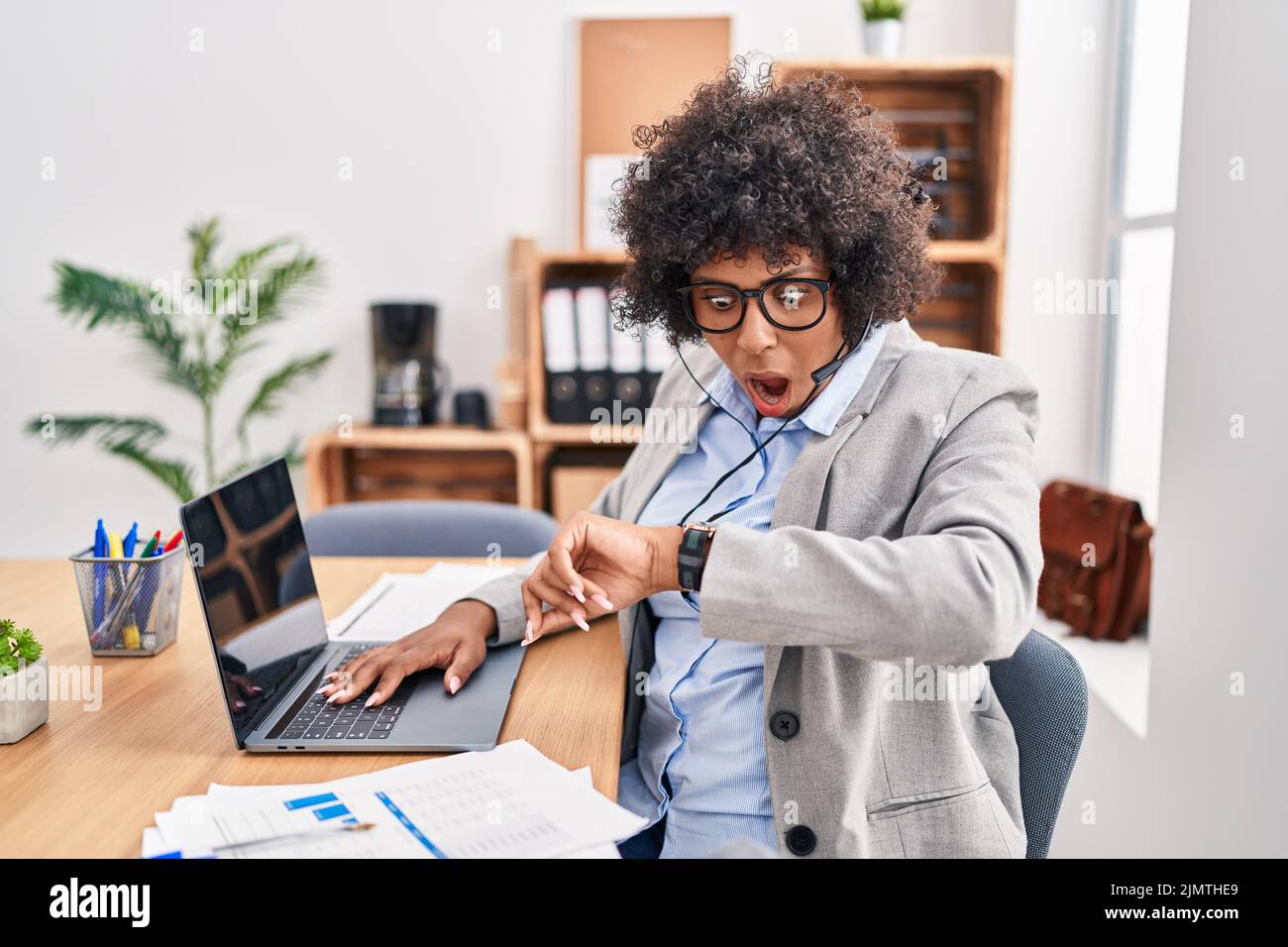 Black woman with curly hair wearing call center agent headset at the ...