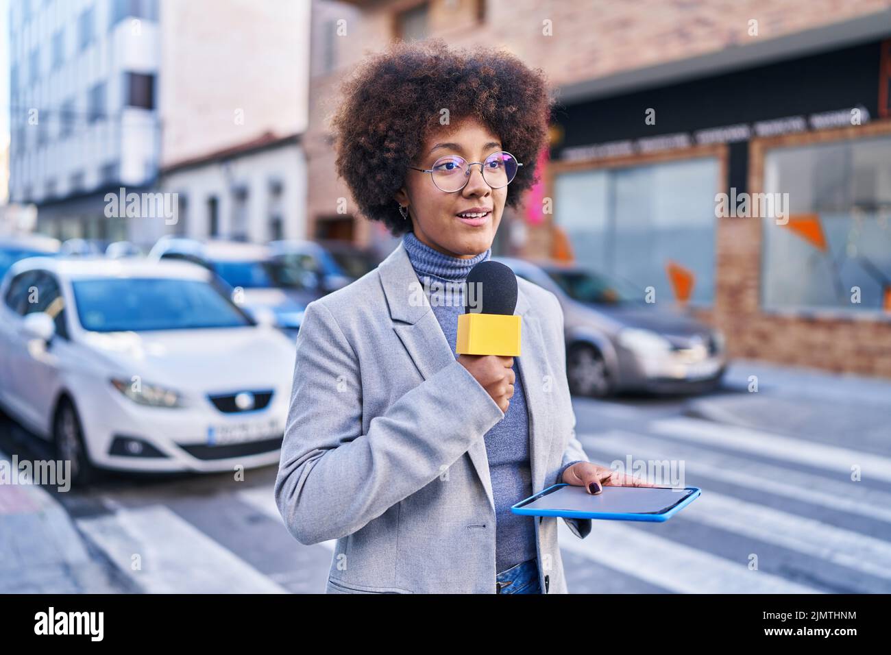 African american woman reporter working using microphone and touchpad ...