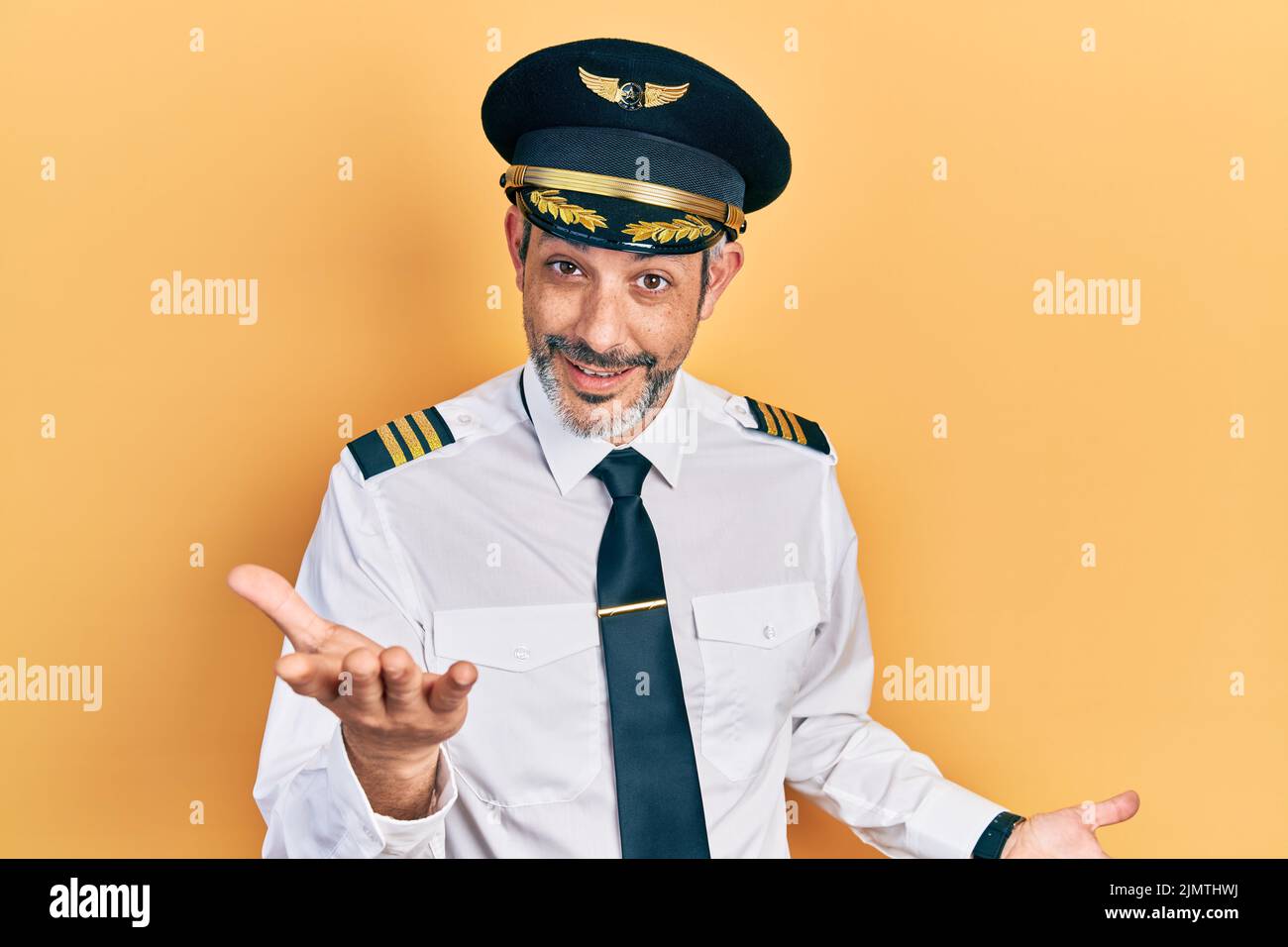 Handsome middle age man with grey hair wearing airplane pilot uniform ...